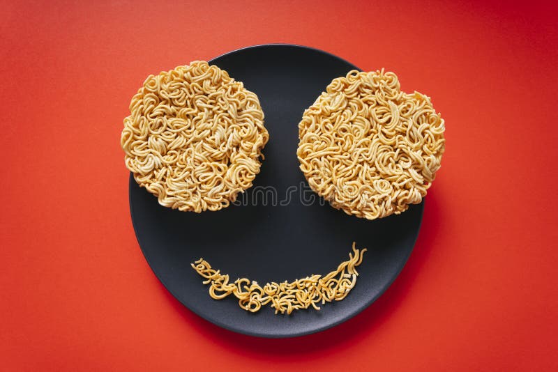 Smiling Face. Instant Noodles on Black Plate Over Red Background Stock ...