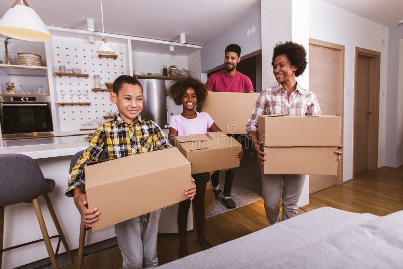 Family Carrying Boxes into New Home on Moving Day Stock Photo - Image ...