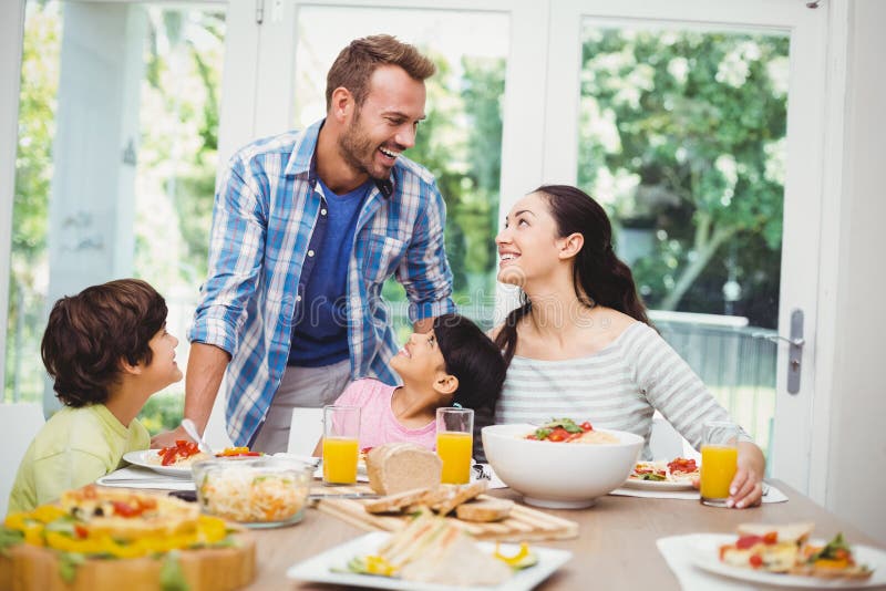 Smiling Family Discussing at Dining Table Stock Photo - Image of ...