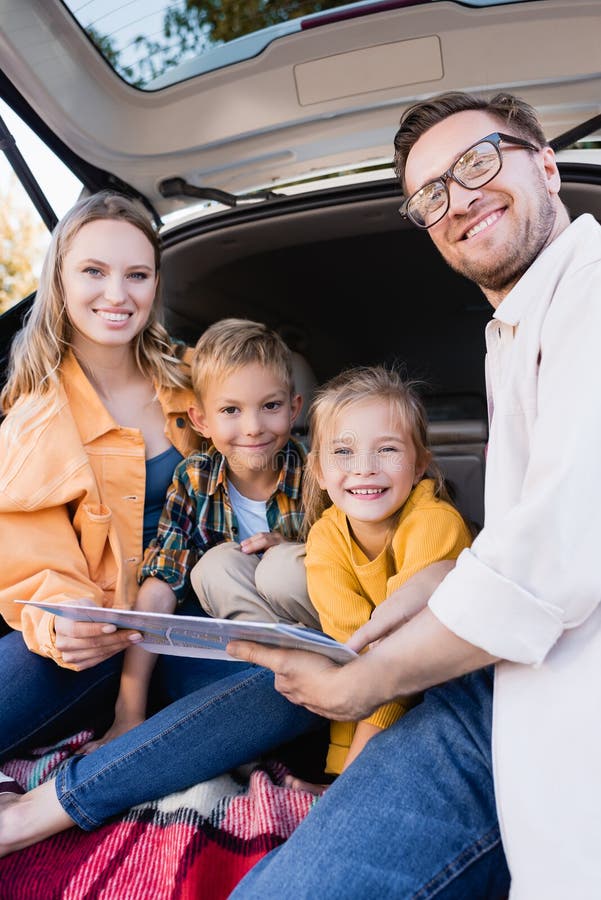 Smiling Family Holding Map in Trunk Stock Image - Image of location ...