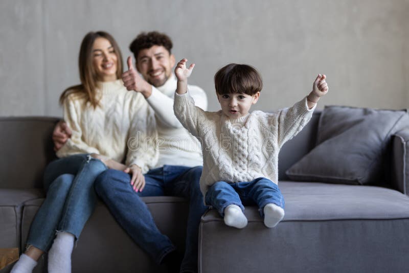 Smiling Win Family Sitting on the Couch Together Stock Photo - Image of ...