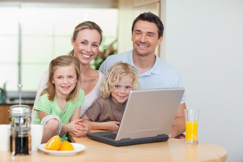 Smiling Family Using the Internet in the Kitchen Stock Photo - Image of ...
