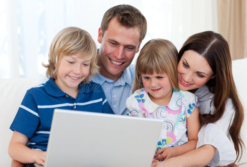 Smiling Family Using a Laptop on the Sofa Stock Photo - Image of ...