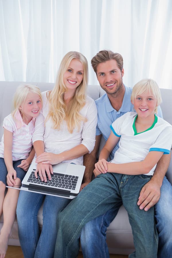 Smiling Family Using Laptop in Their Living Room Stock Image - Image of ...