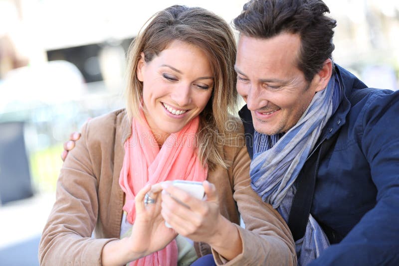 Smiling Fancy Couple in Town Using Smartphone Stock Image - Image of ...