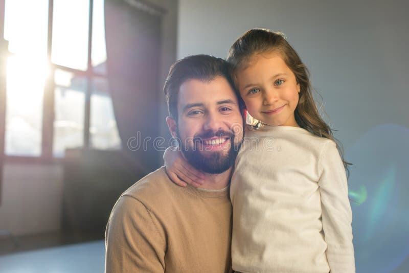 Smiling Father And Daughter Posing In Room And Looking Stock Image