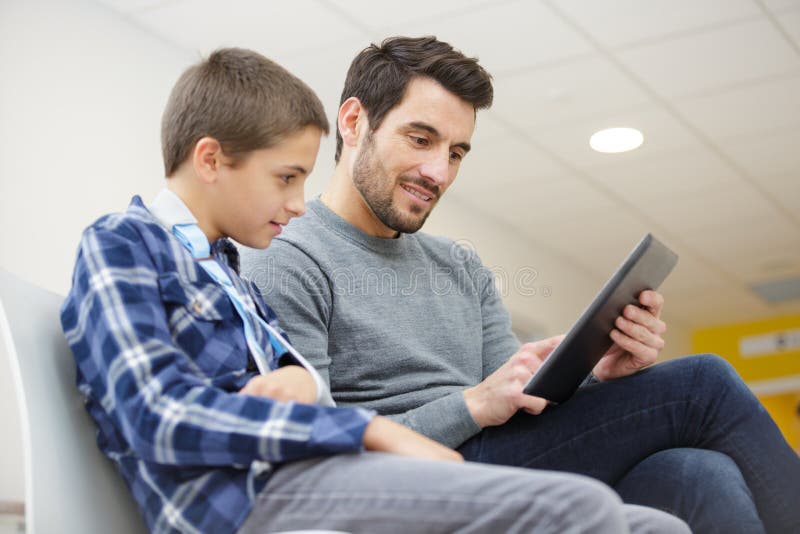 Smiling Father and Son Waiting for Doctor in Hospital Stock Image ...