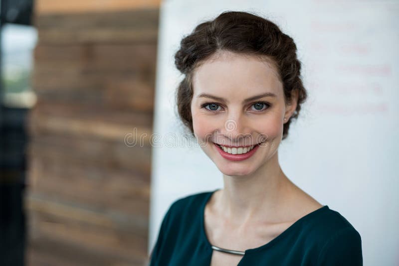 Smiling Female Business Executive Standing in Office Stock Photo ...