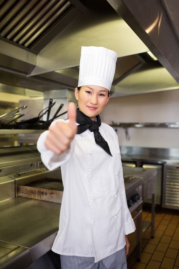 Smiling Female Cook Gesturing Thumbs Up in Kitchen Stock Photo - Image ...