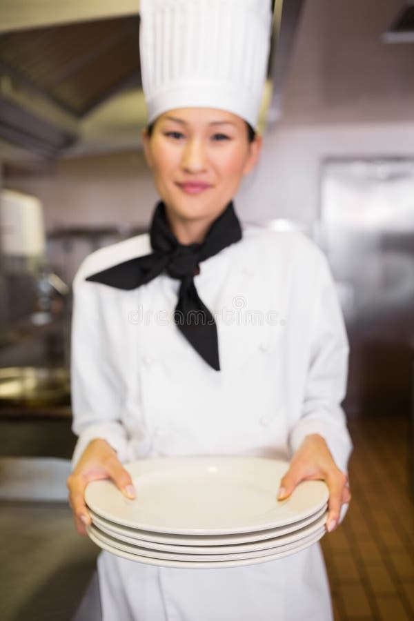 Smiling Female Cook Holding Empty Plates in Kitchen Stock Image - Image ...