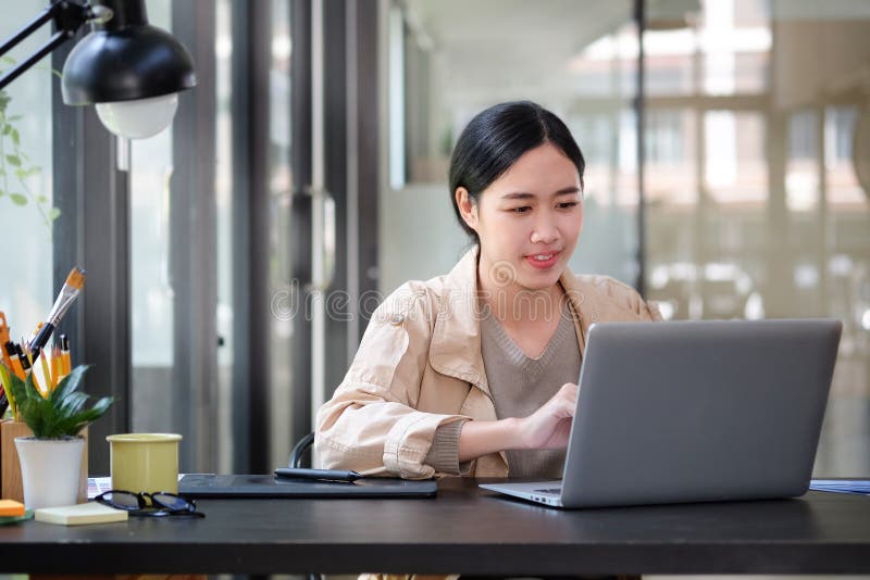 Smiling Female Creative Designer Using Computer Laptop at Her Workplace ...