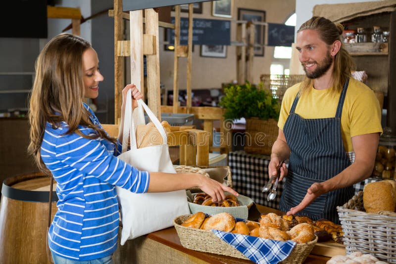 Smiling Female Customer Interacting with Staff at Counter Stock Photo ...