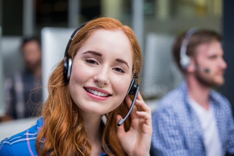 Smiling Female Customer Service Executive Talking on Headset at Desk ...