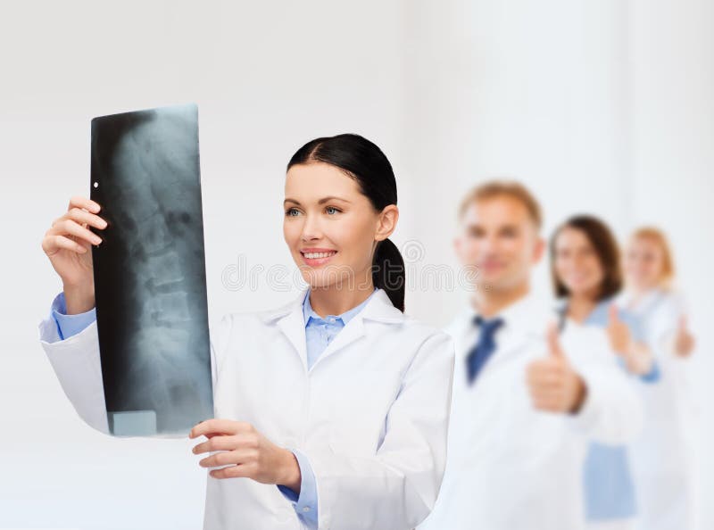 Smiling Female Doctor Looking at X-ray Stock Photo - Image of holding ...