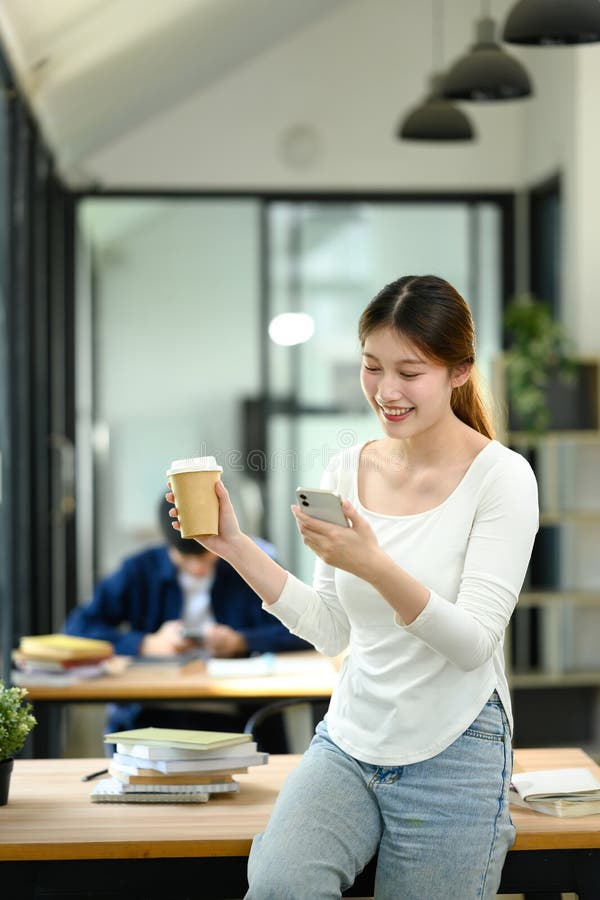 Smiling Female Employee Using Mobile Phone in Modern Office Stock Photo ...