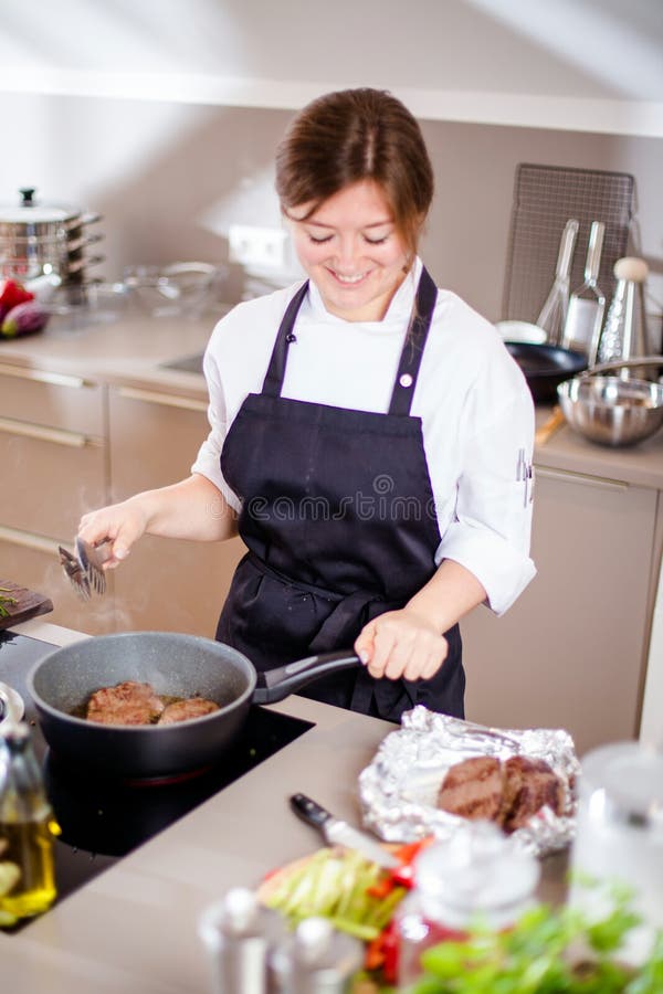 Smiling Female Kitchener in Uniform is Standing in the Kitchen at the ...
