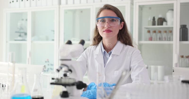 Smiling Female Lab Technician Sits at Table with Microscope Stock ...