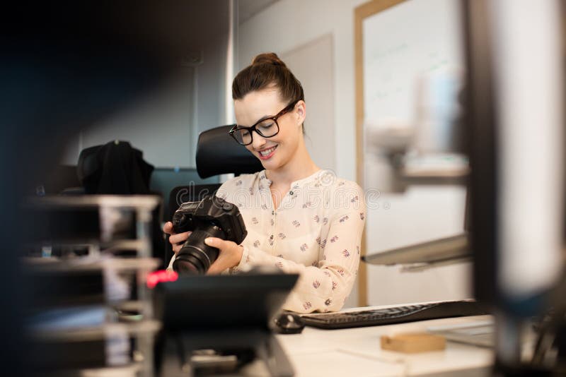 Smiling Female Photographer Using Camera at Creative Office Stock Image ...