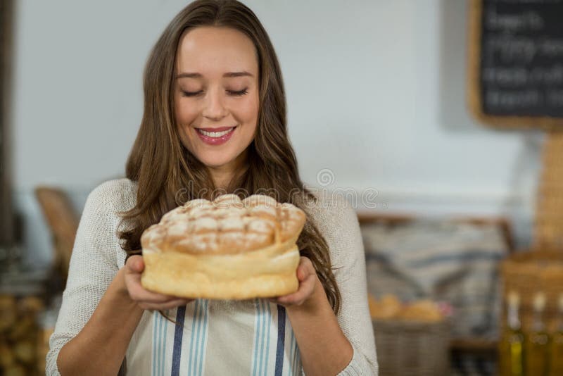 Smiling Female Staff Holding Round Loaf of Bread at Counter Stock Photo ...