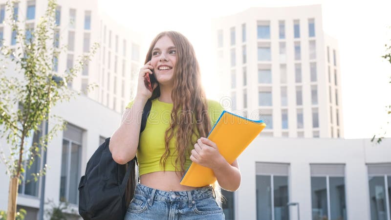 Smiling Female Student Chatting on Cellphone on University Campus Stock ...
