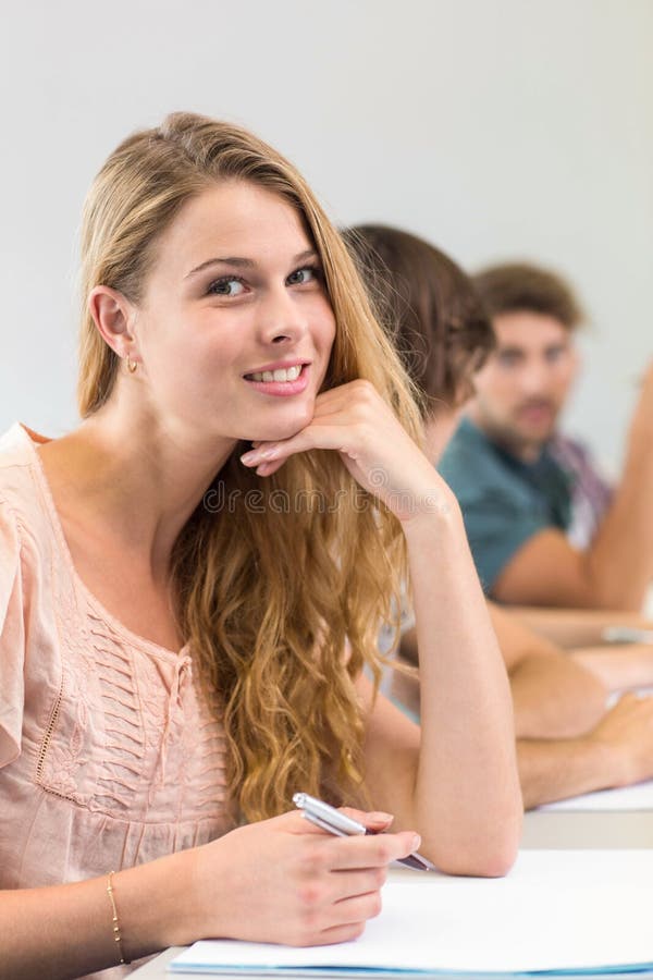 Smiling Female Student Writing Notes in Classroom Stock Image - Image ...
