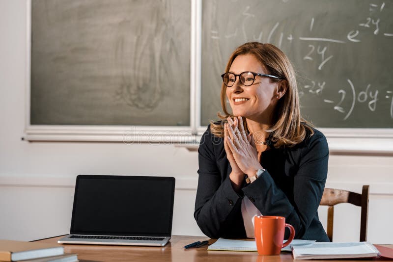 Smiling Female Teacher Sitting at Computer Desk with Blank Screen Stock ...