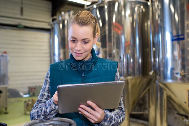 Smiling Female Worker Using Digital Tablet in Manufacturing Industry ...