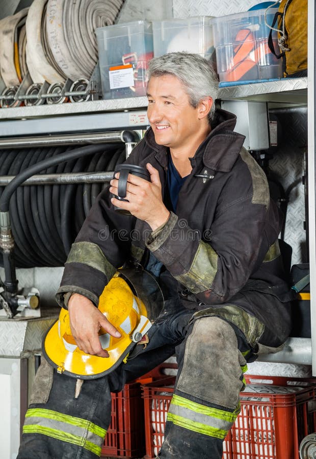 Smiling Fireman Sitting in Truck at Fire Station Stock Photo - Image of ...