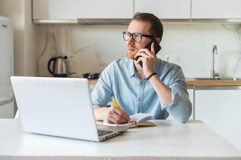 Smiling Freelancer Guy Working from Home, Sits at the Kitchen Desk ...