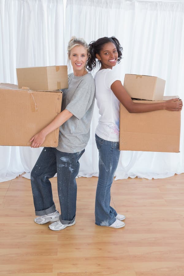 Happy Friends Standing Back To Back Holding Moving Boxes Stock Photos ...