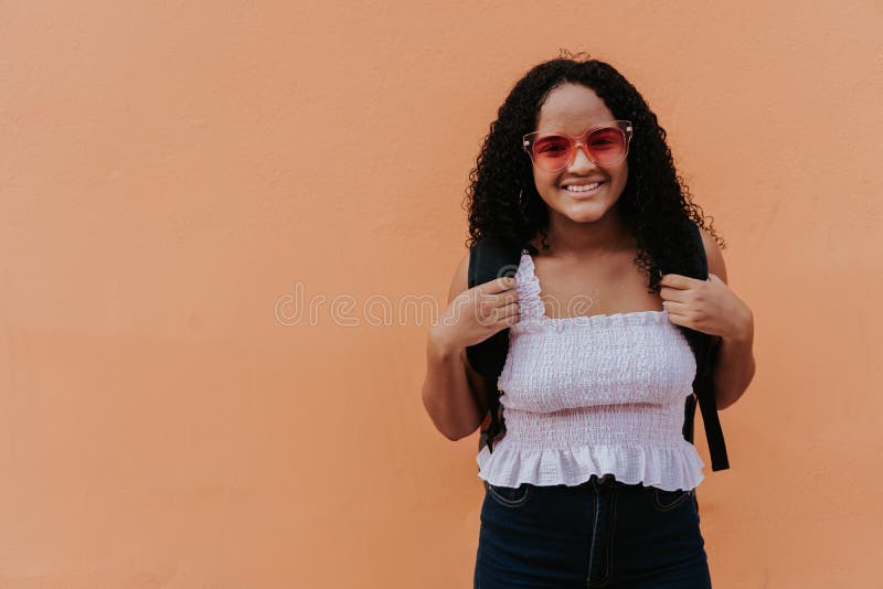 Smiling Girl Carrying Backpack while Standing in Front of Wall Stock ...