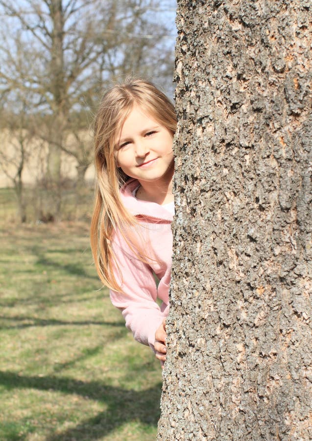 Smiling Girl Hiding Behind Tree Stock Photo - Image of forest, blondie ... Smiling Girl Hiding Behind Tree Stock Photo - Image of forest, blondie ...