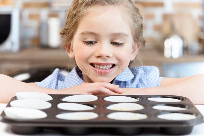 Smiling Girl Looking at Baking Form for Cupcakes Stock Image - Image of ...