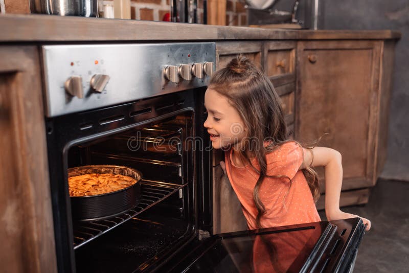 Smiling Girl Looking at Cake in Oven in Kitchen Stock Image - Image of ...
