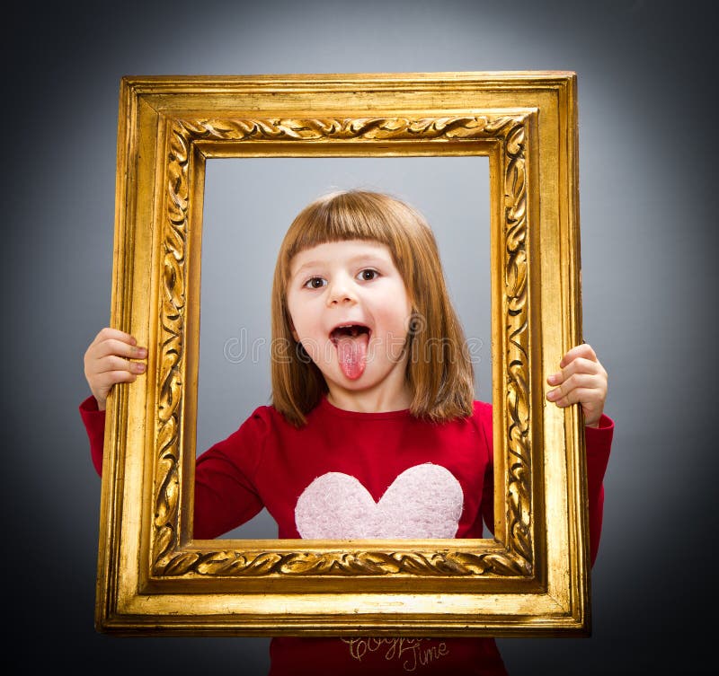 A Smiling Girl Looking through a Vintage Picture Frame Stock Photo ...