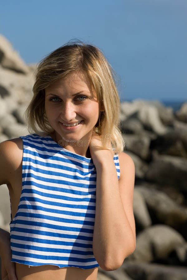 Smiling Girl on a Rocky Beach by the Sea. Stock Image - Image of blue ...