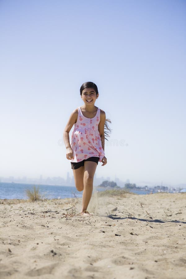 Smiling Girl Running on Beach Stock Photo - Image of smile, outdoors ...