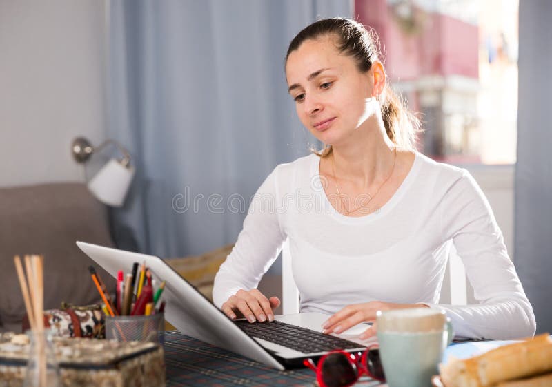 Smiling Girl Sitting at Table at Home Calculating Domestic Finances and ... Smiling Girl Sitting at Table at Home Calculating Domestic Finances and ...