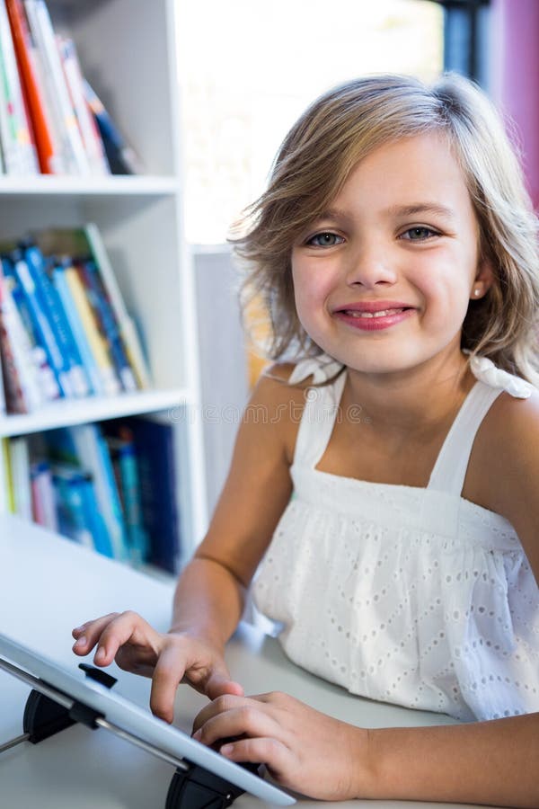 Smiling Girl Using Digital Tablet in School Library Stock Photo - Image ...