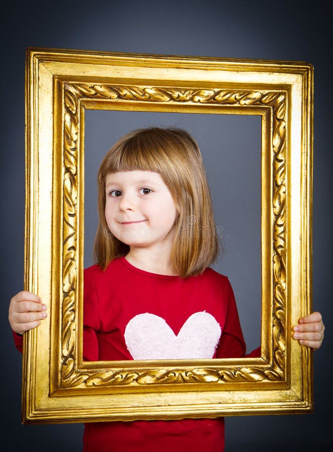 A Smiling Girls Looking through a Vintage Picture Frame Stock Photo ...
