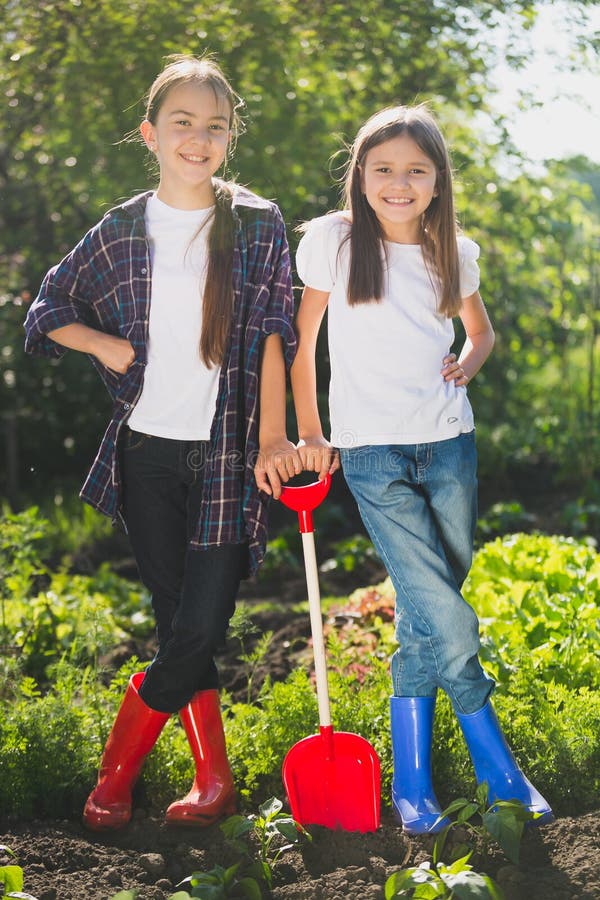 Smiling Girls in Rubber Boots Posing at Garden with Shovel Stock Photo ...