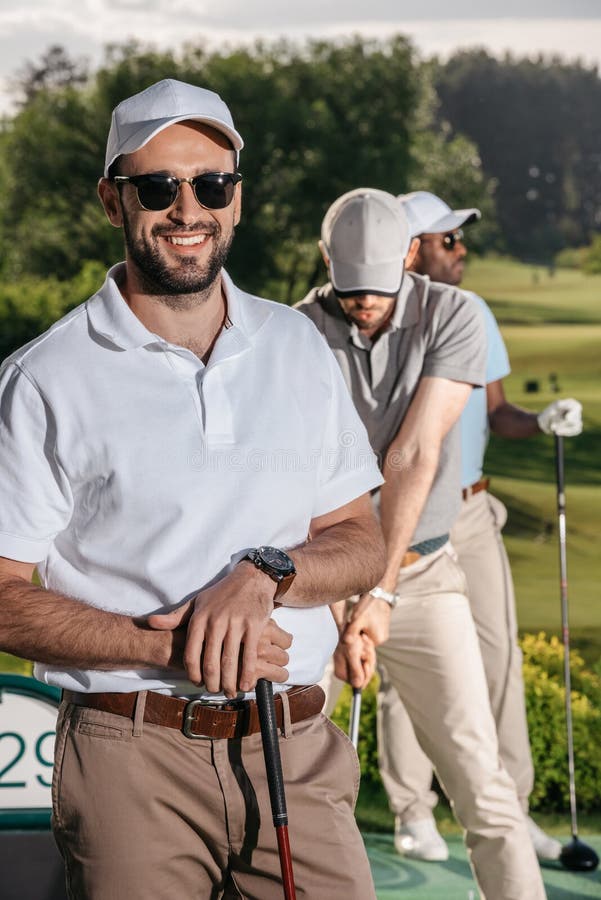 Smiling Golfer Looking at Camera while Men Playing Golf Stock Image ...