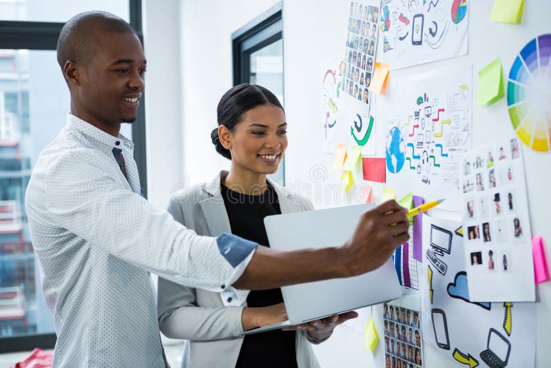 Smiling Graphic Designers Discussing Over Charts and Graph Stock Photo ...
