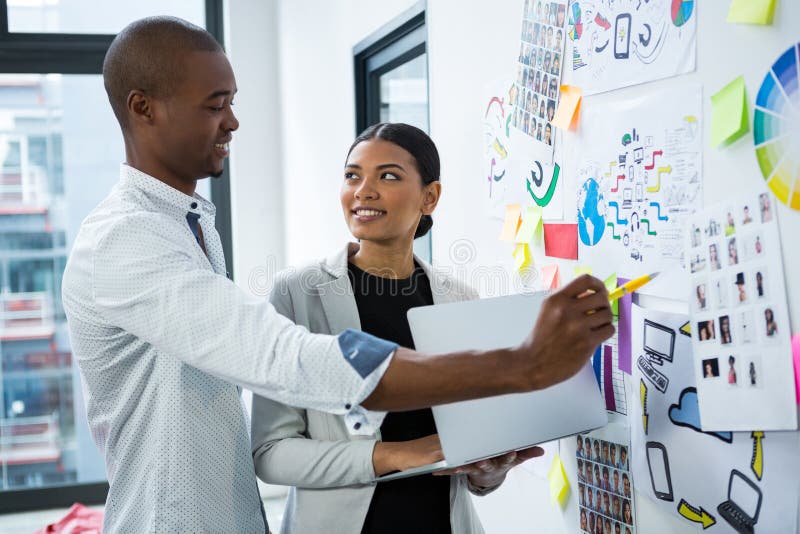 Smiling Graphic Designers Discussing Over Charts and Graph Stock Image ...