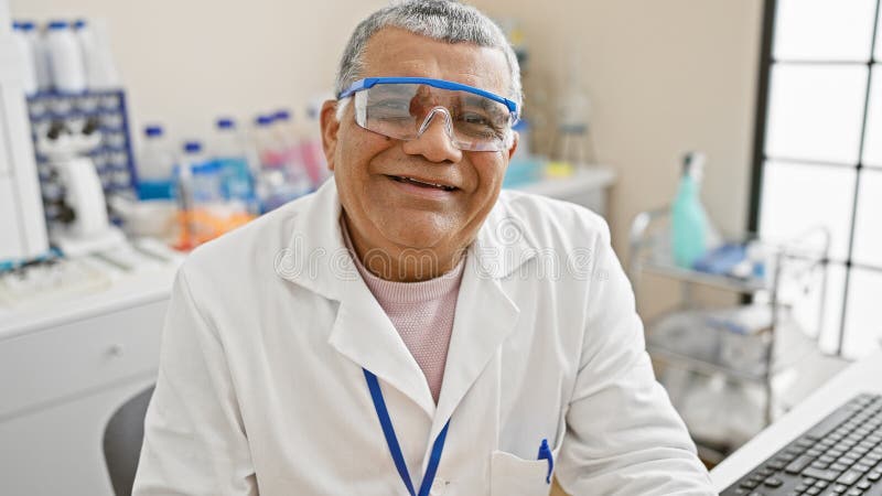 Smiling Grey-haired Man in Lab Coat and Safety Glasses Sitting in a ...
