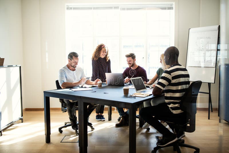Smiling Group of Designers Talking Together Around an Office Tab Stock ...