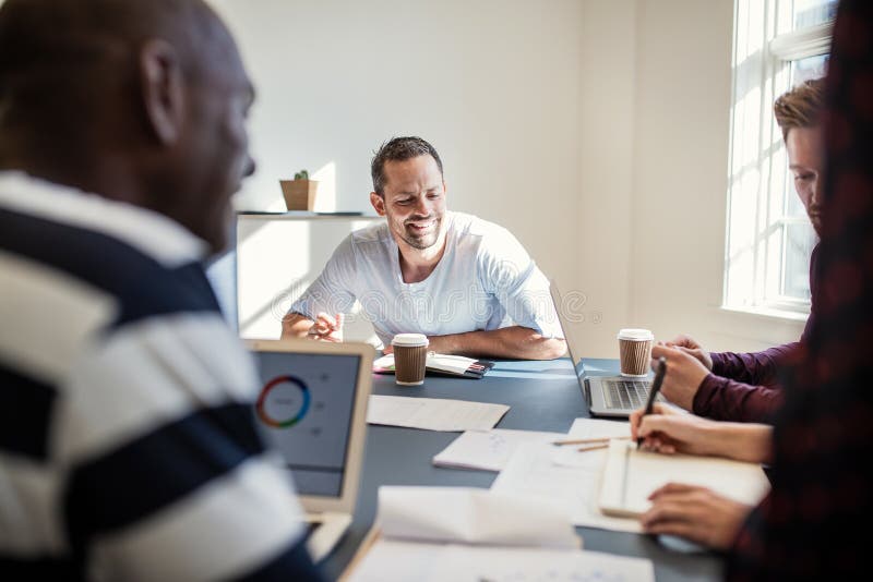 Smiling Group of Designers Talking Together Around an Office Tab Stock ...