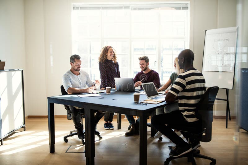 Smiling Group of Designers Working Together Around an Office Tab Stock ... Smiling Group of Designers Working Together Around an Office Tab Stock ...