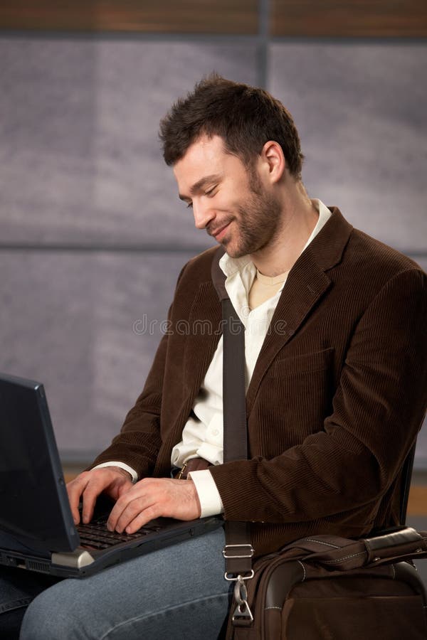 Smiling guy with laptop stock image. Image of building - 16892177