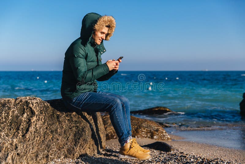 Smiling Guy Using His Smartphone on the Beach. Stock Photo - Image of ...